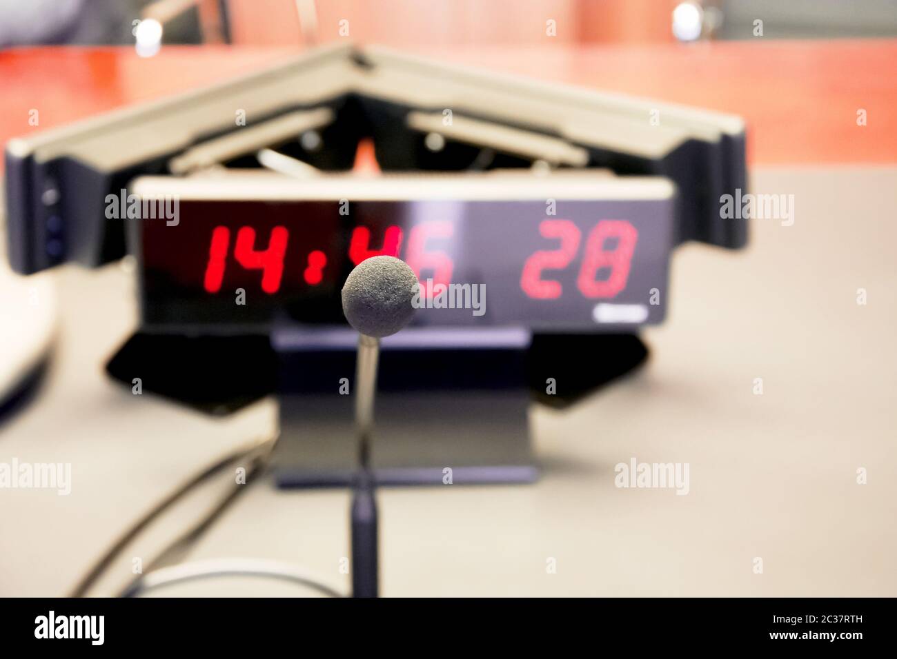 a table microphone on the wooden table of a board in front of a digital ...