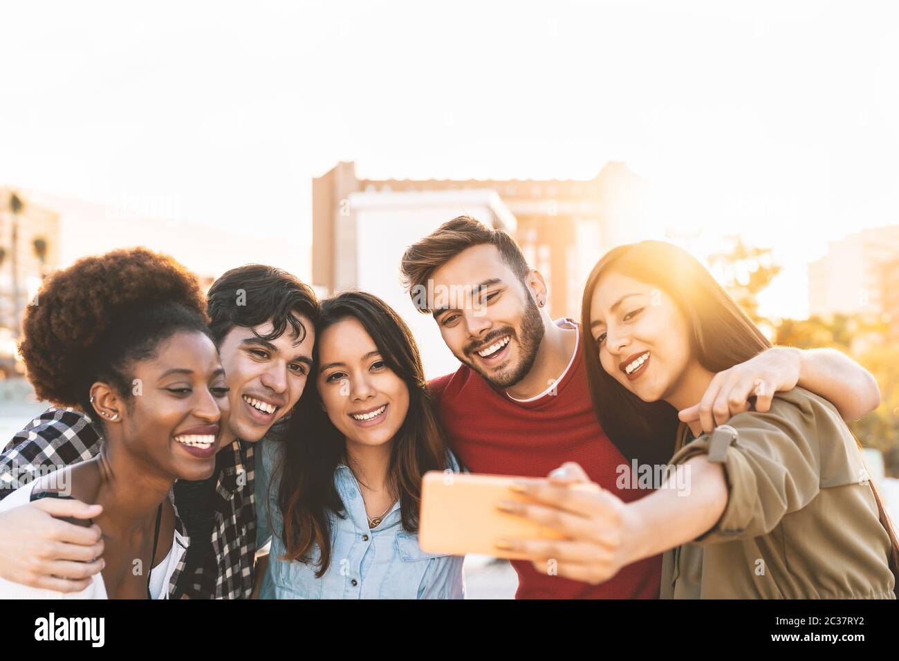 Group multiracial friends taking selfie with mobile smartphone outdoor - Happy mixed race people ...