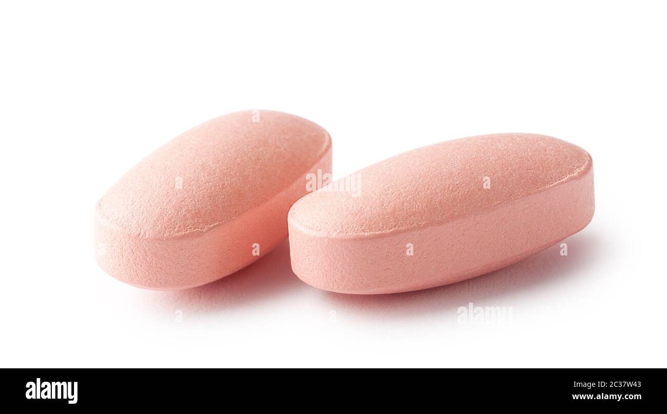 Two pink pills isolated on white background Stock Photo - Alamy