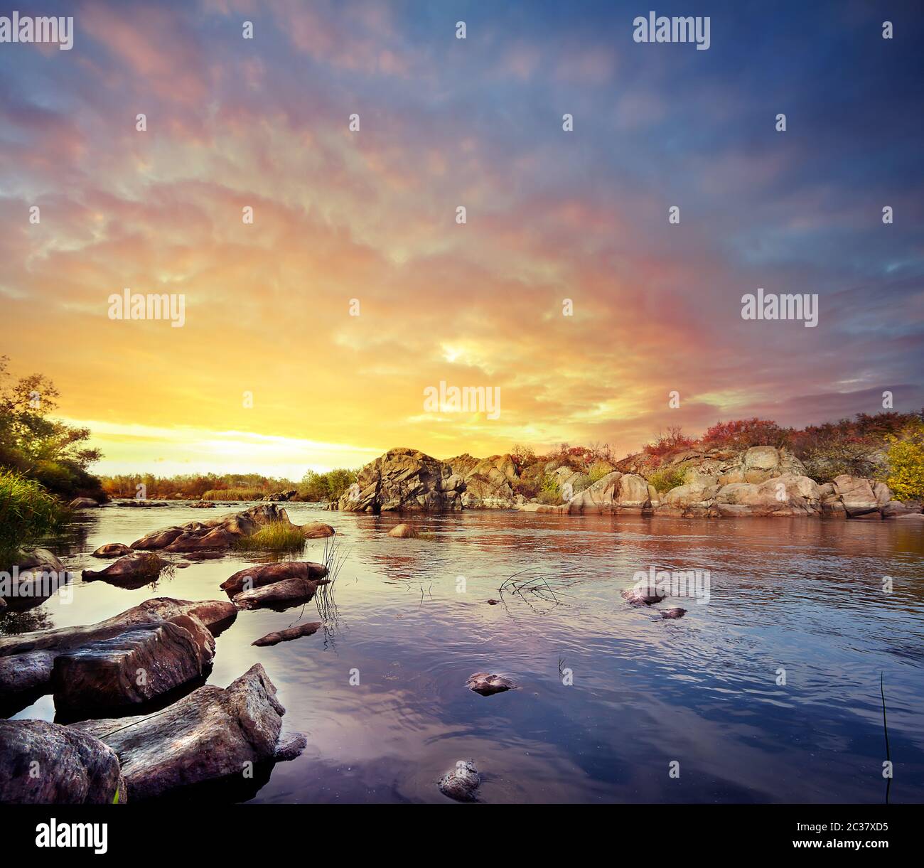 Mining fast river under dramatic sunset sky Stock Photo - Alamy