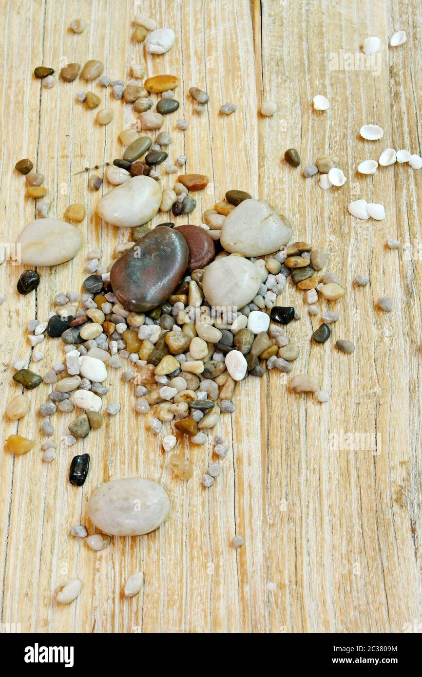 Bunch of stones and pebbles at wooden board Stock Photo - Alamy