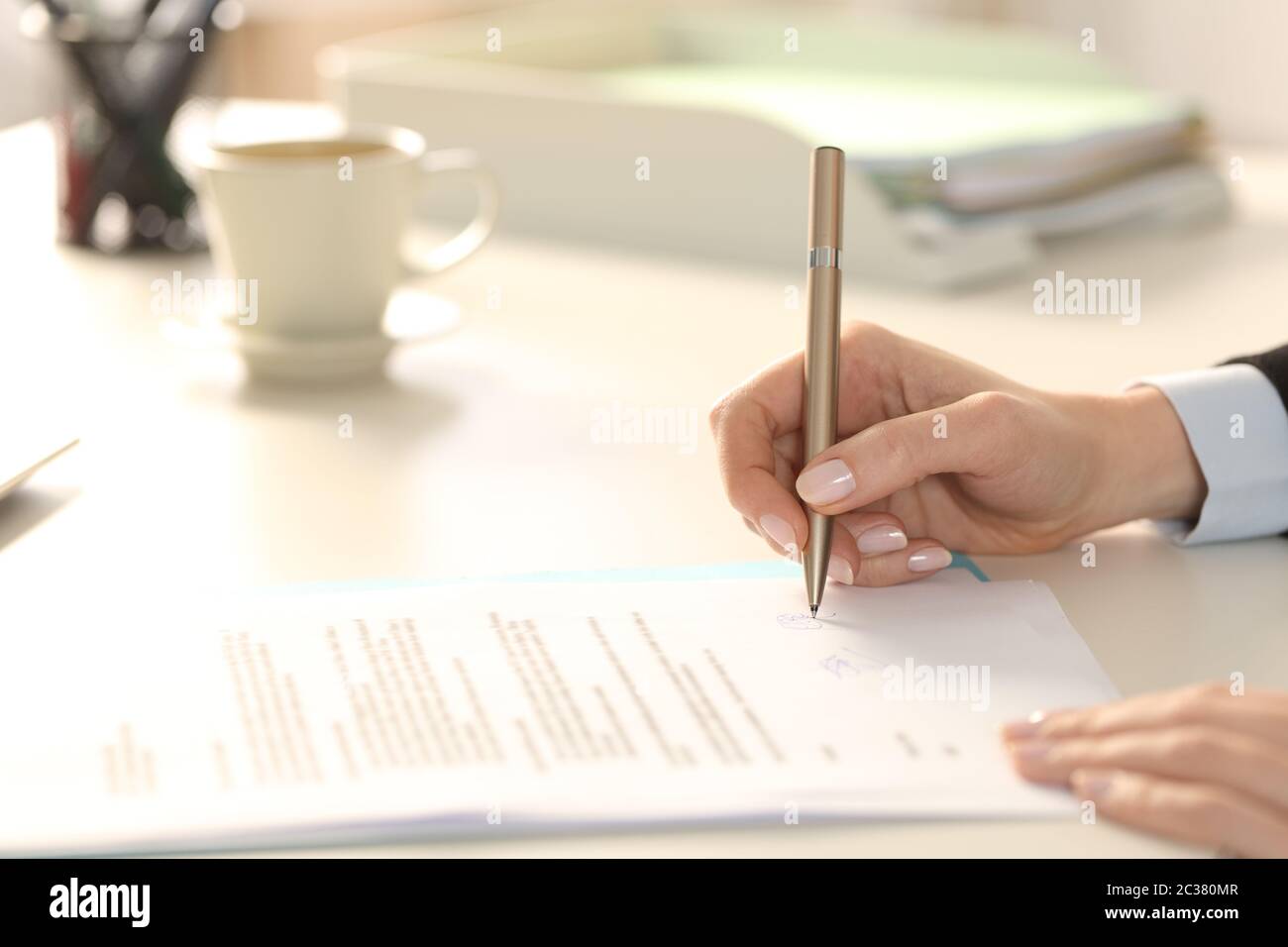 Close up of business woman hand signing contract sitting on a desk in ...