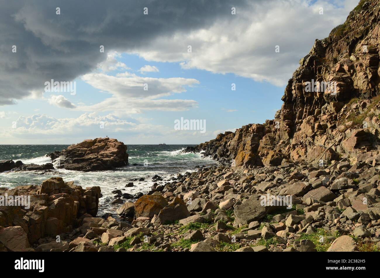 The rocky coastline and cloudy sky Stock Photo - Alamy