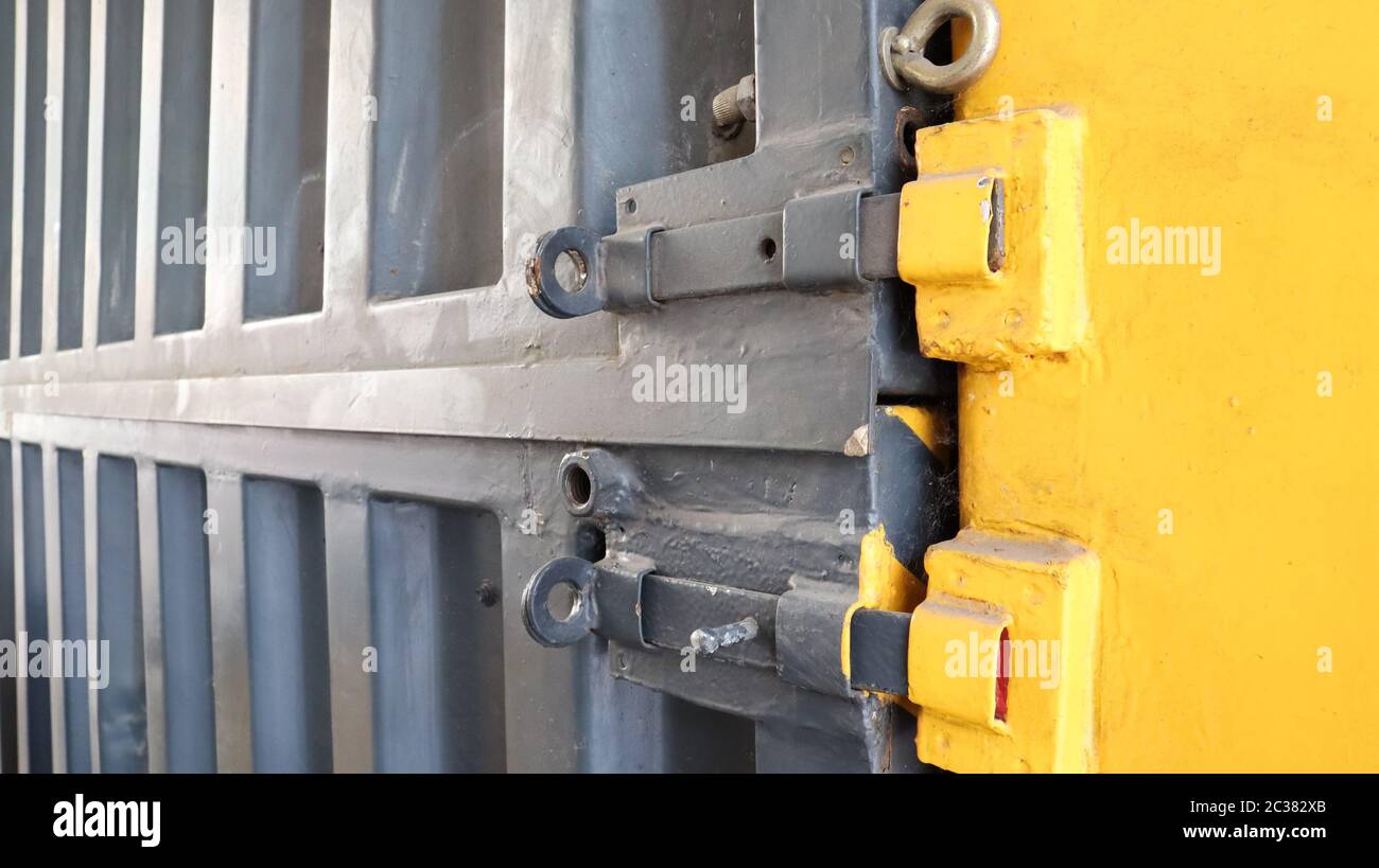 Latch and lock of a standard yellow and gray metallic sea cargo ...