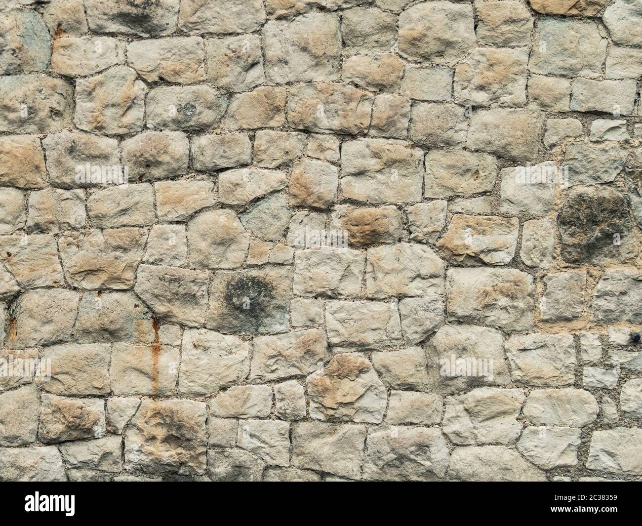 Wall of a medieval fortress with mainly white or light colored stones ...