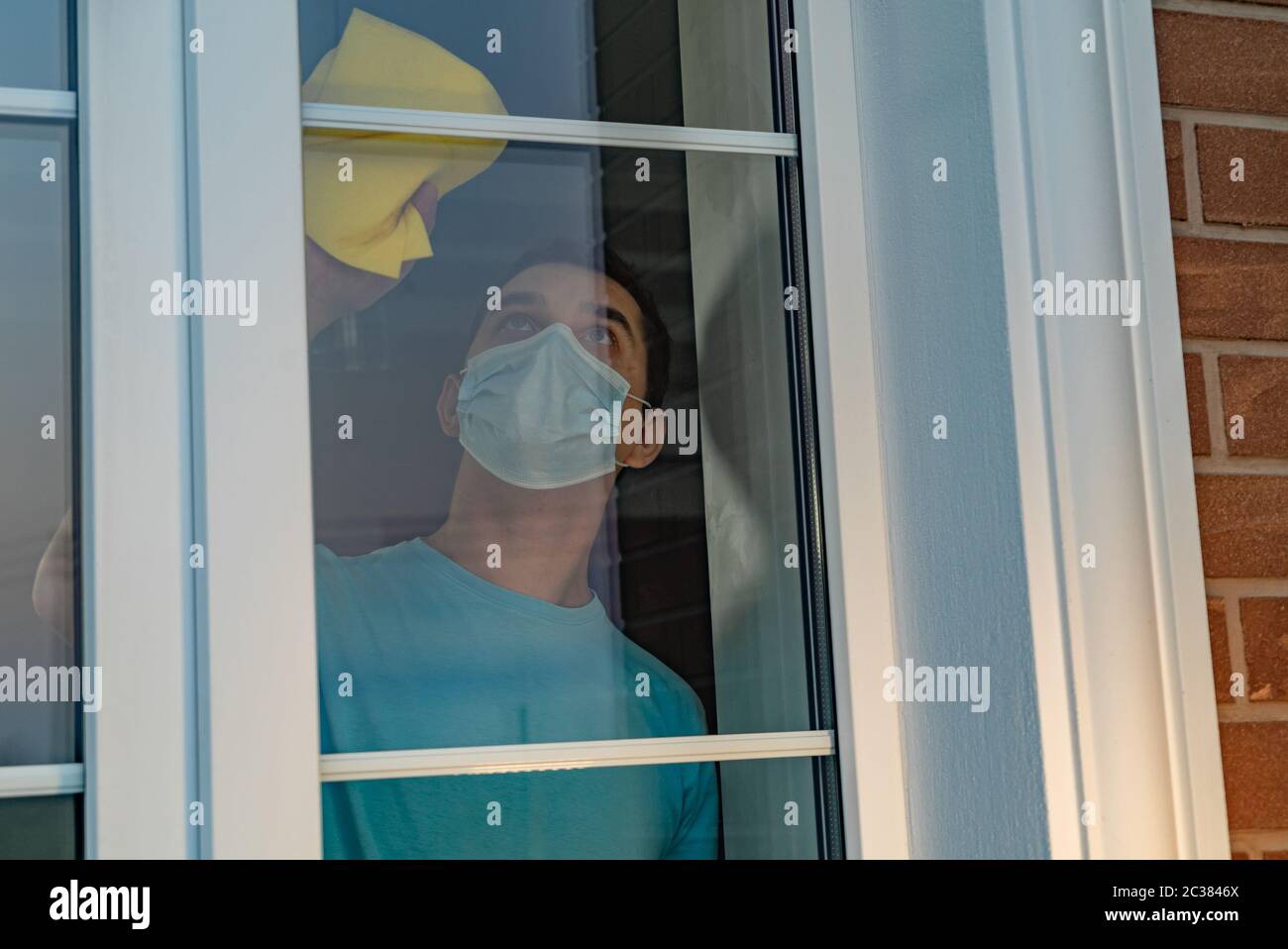 Hospital window cleaning disinfection. Man in a medical mask cleans ...