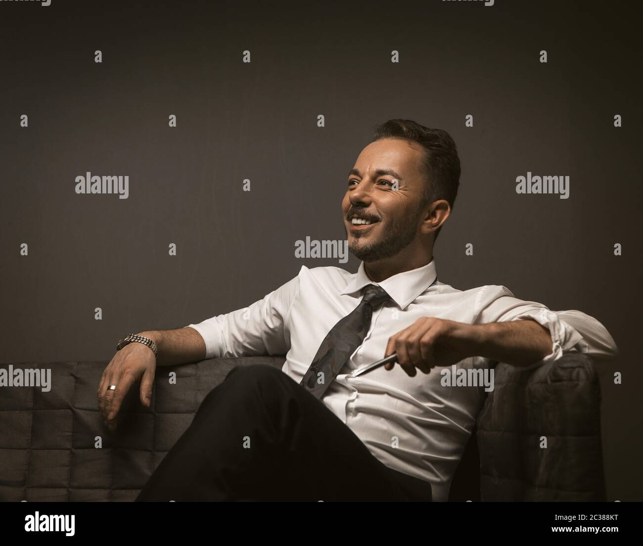 Cheerful Caucasian businessman smiles looking at side on interlocutor ...