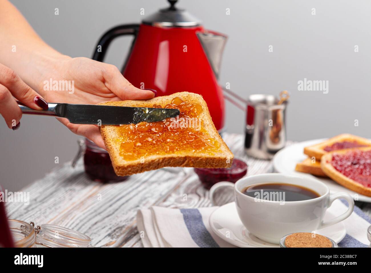 Female hands preparing toasts with fruit jam Stock Photo - Alamy