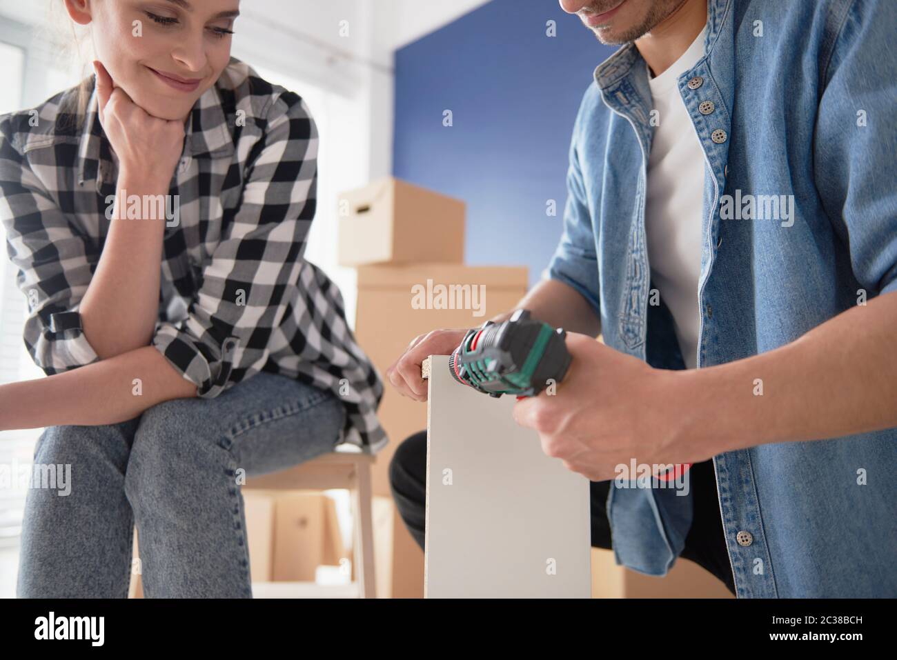 Couple installing furniture in their new home Stock Photo - Alamy