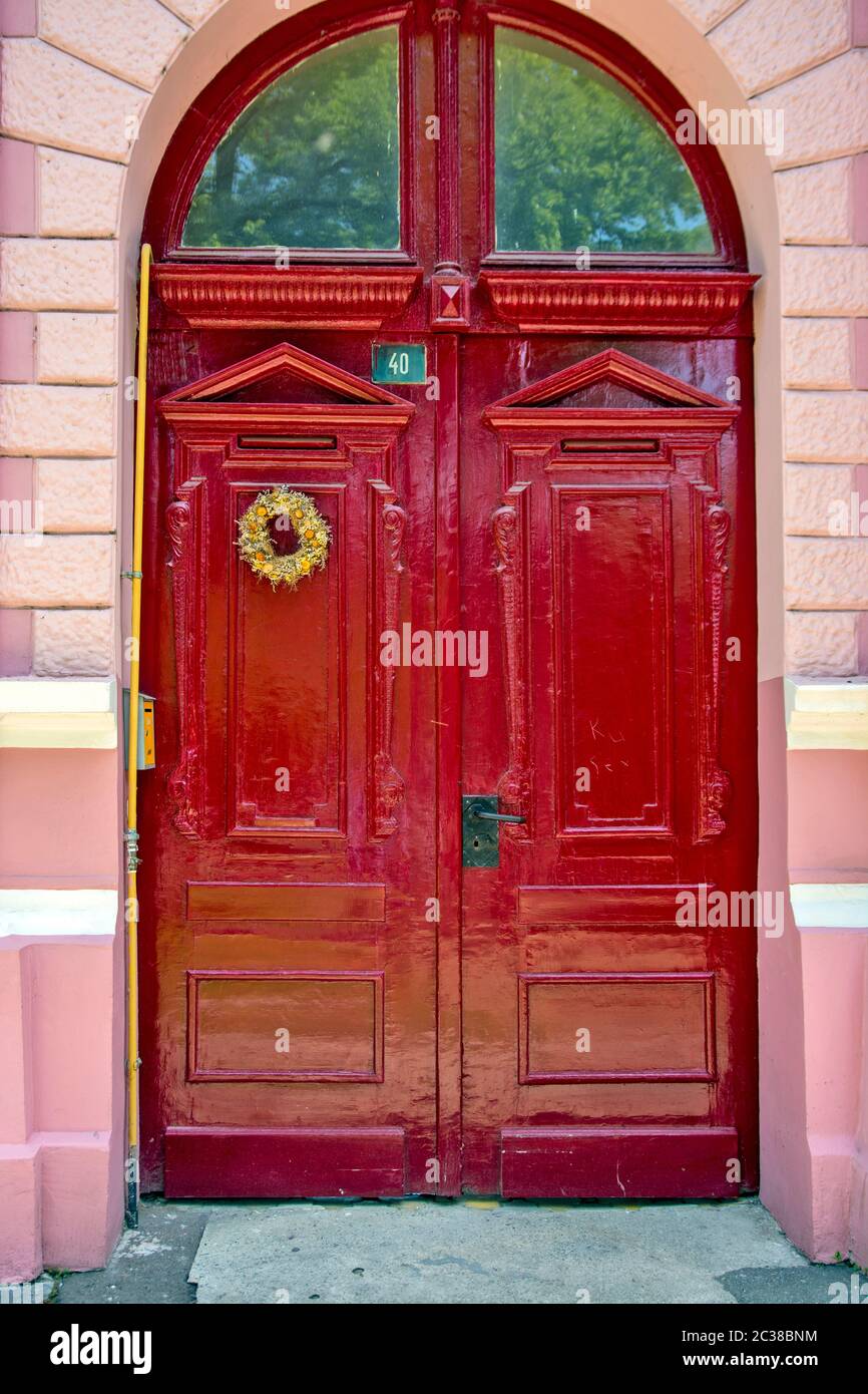 A beautiful big red old wooden gate in an old preserved city street ...