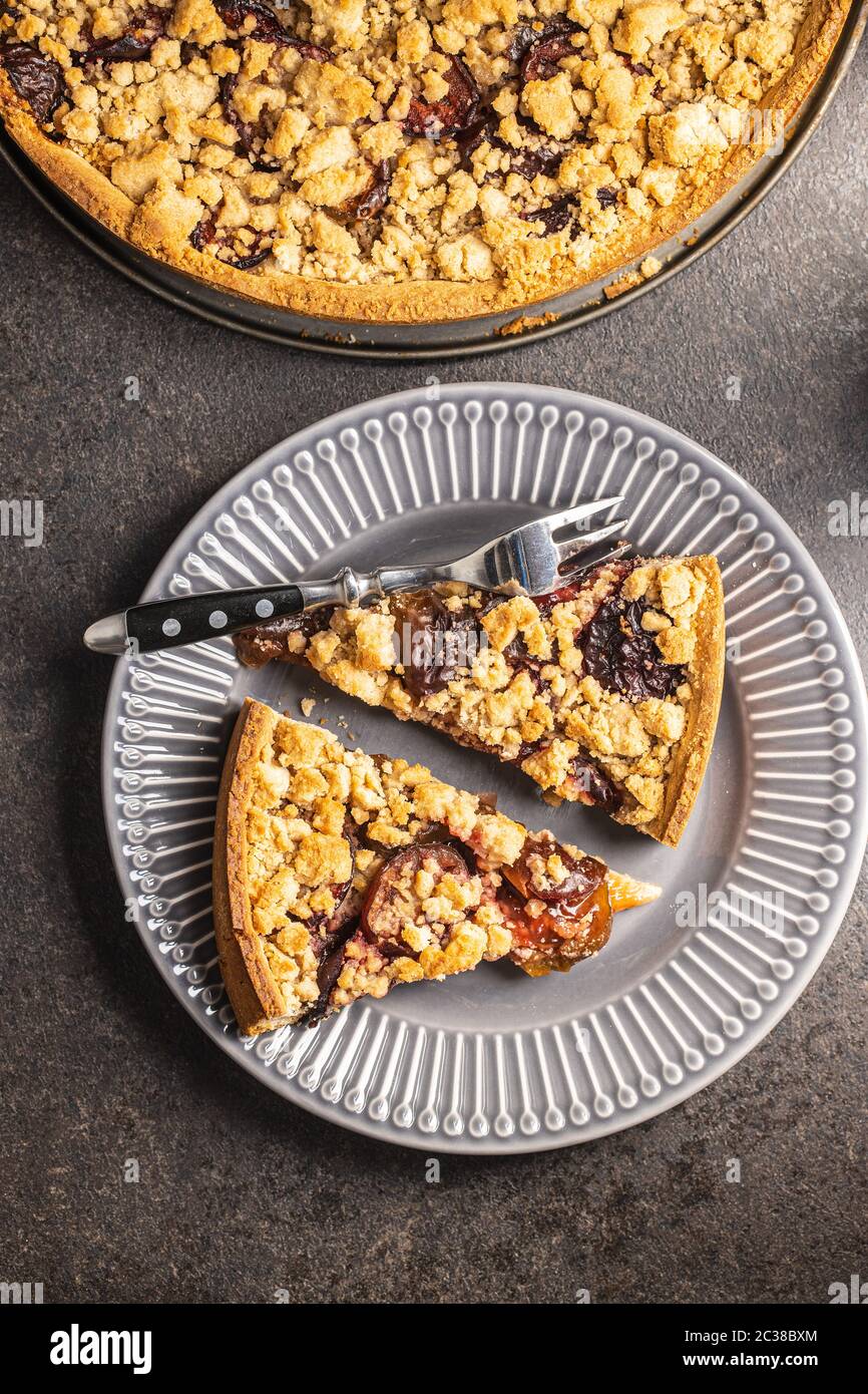 Sweet plum pie. Cut pieces of pie on plate. Top view Stock Photo - Alamy