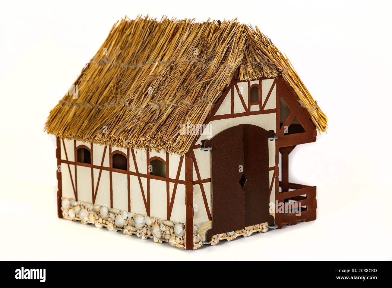 Toy house made of rural cardboard with a thatched yellow roof on a ...