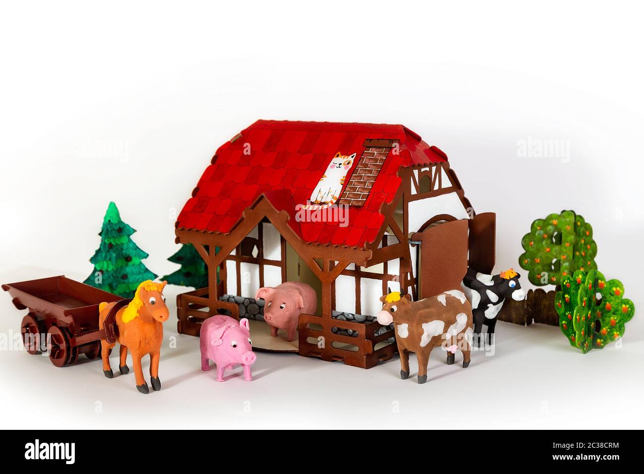Toy house made of cardboard paints with toy pets, farm yard on a light ...