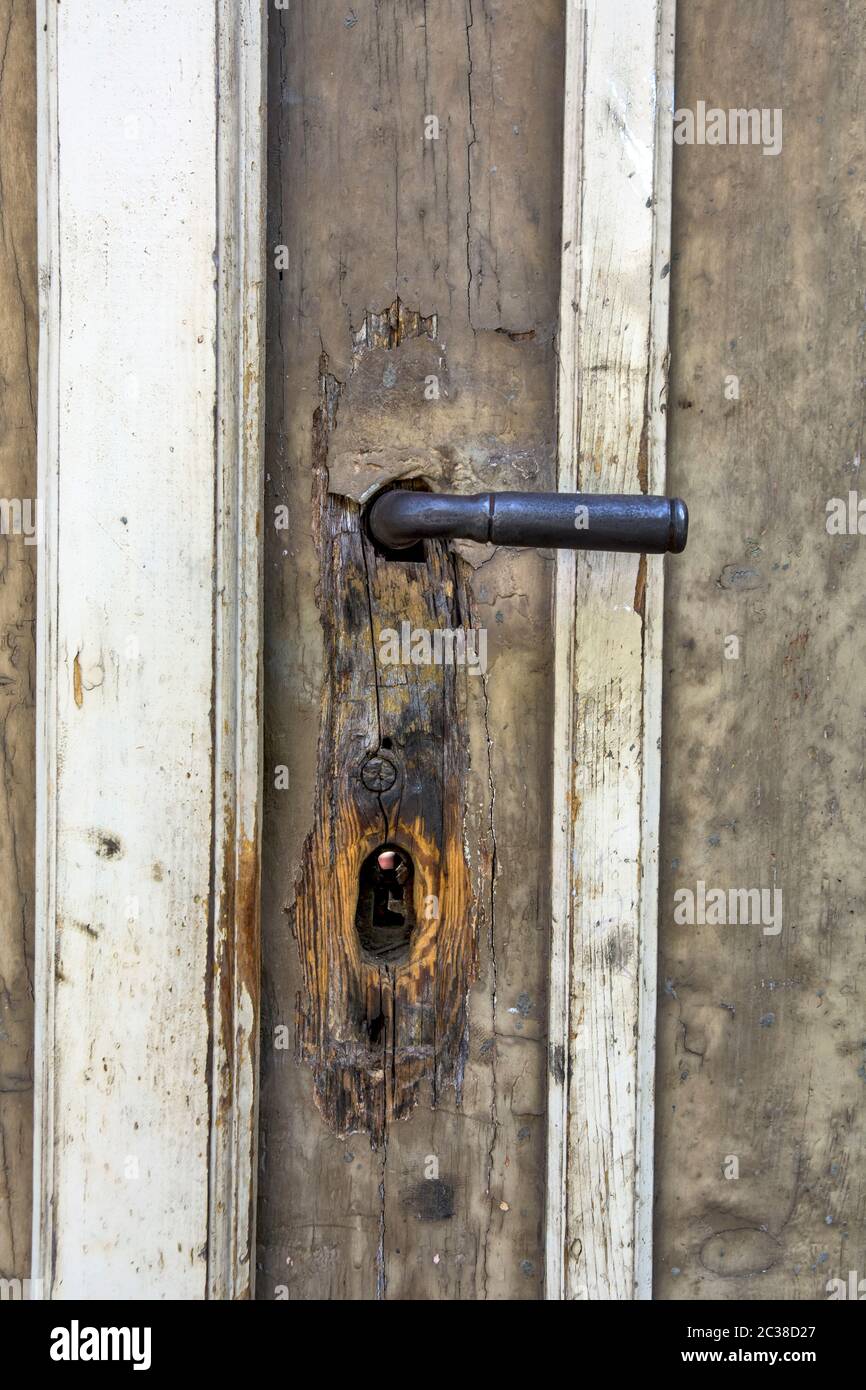 Old wooden front door. House gate with a handle and a lock on the old ...