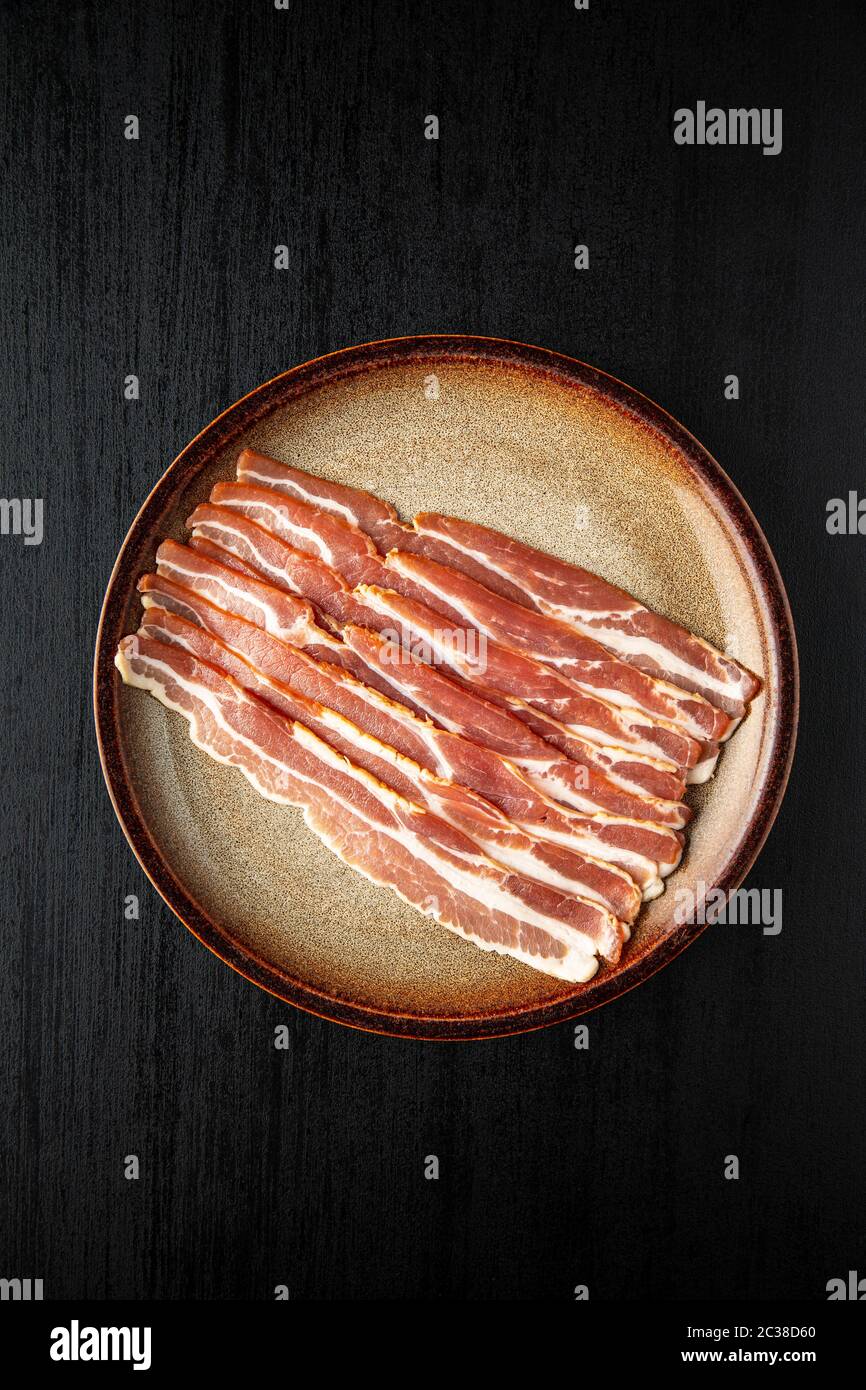 Smoked bacon strips on plate. Top view Stock Photo - Alamy