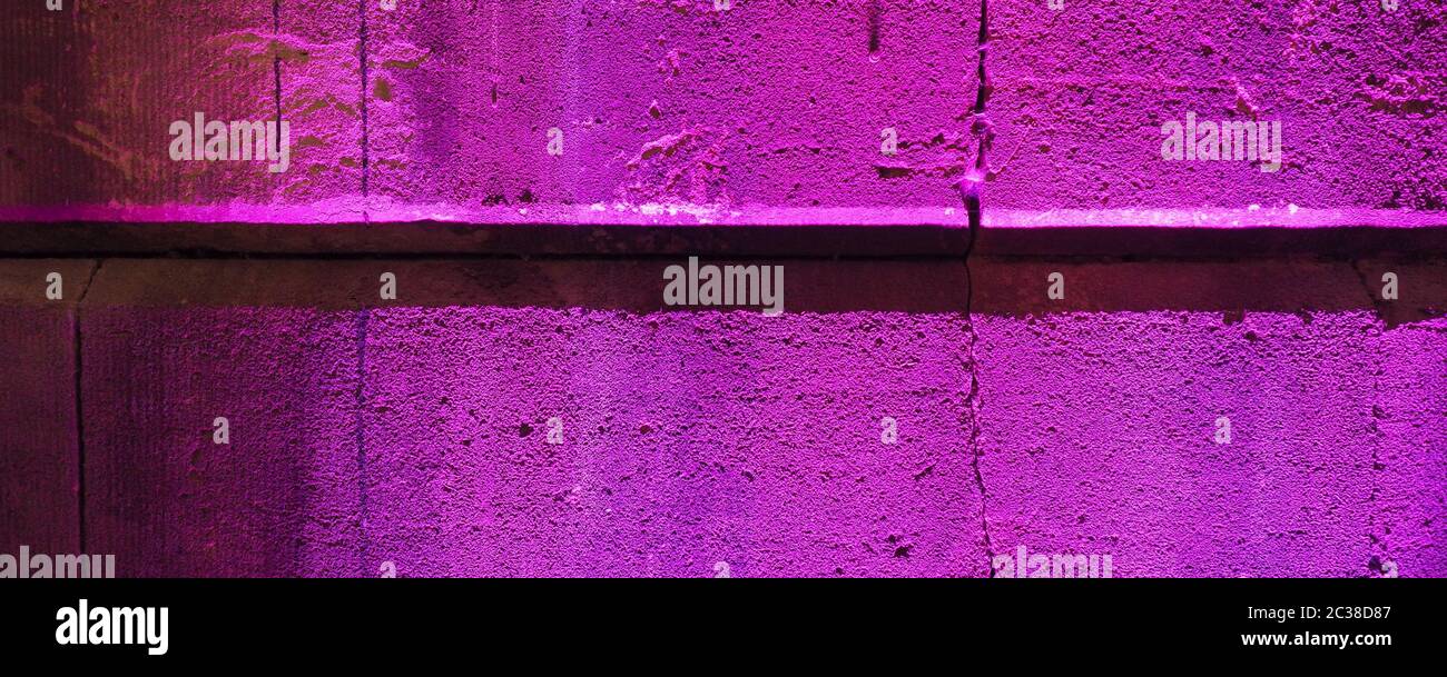 wide violet light illuminated concrete texture useful as a background ...