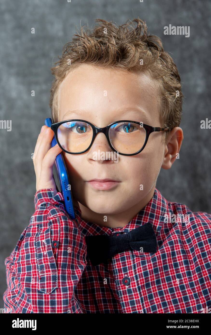 a young boy using a smartphone for talking Stock Photo - Alamy
