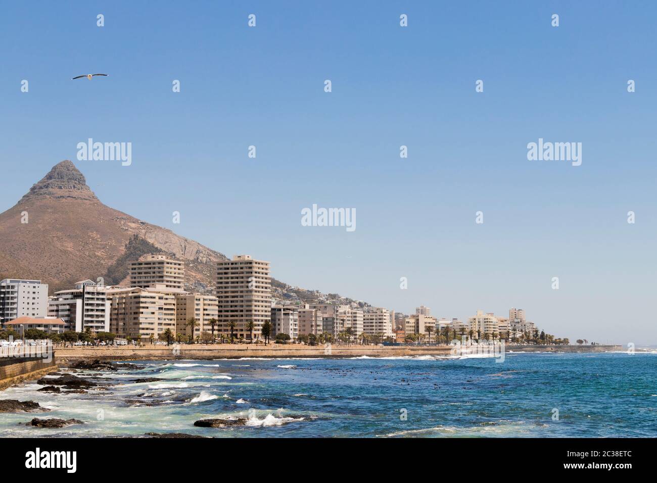Mountains, hotels and deep blue water with waves at the Sea Point ...