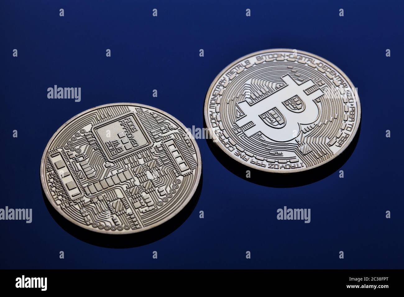 The front and back of the virtual currency bitcoin on a blue background ...