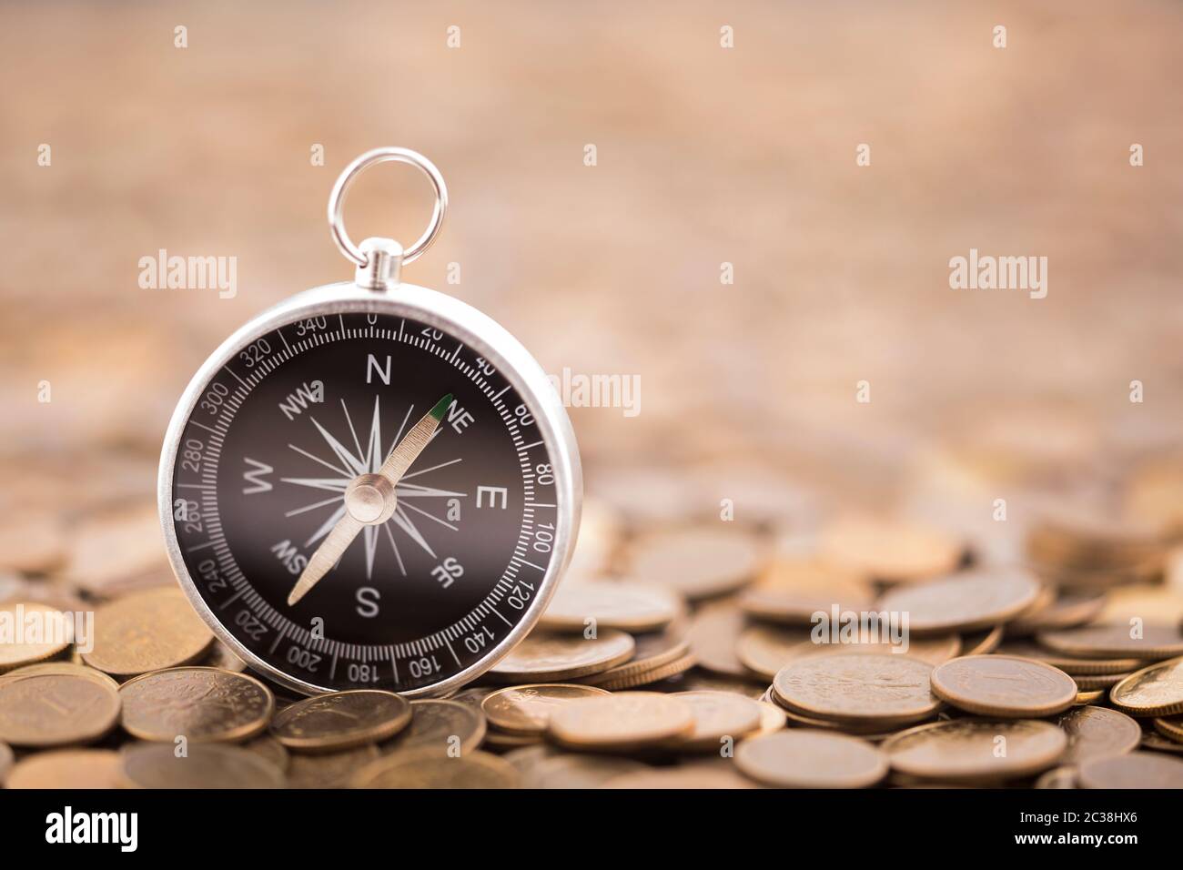 Financial concept with coins and compass Stock Photo - Alamy