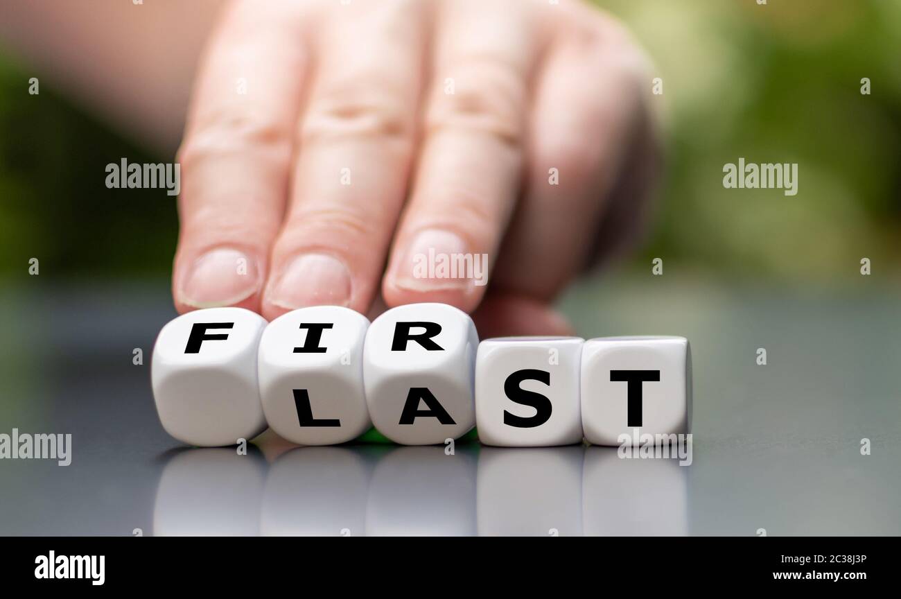 Hand turns dice and changes the word "last" to "first Stock Photo - Alamy
