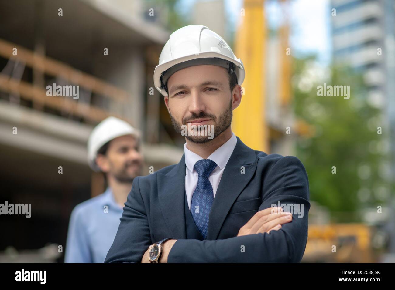 Building site. Building supervisor standing with folded arms, foreman ...