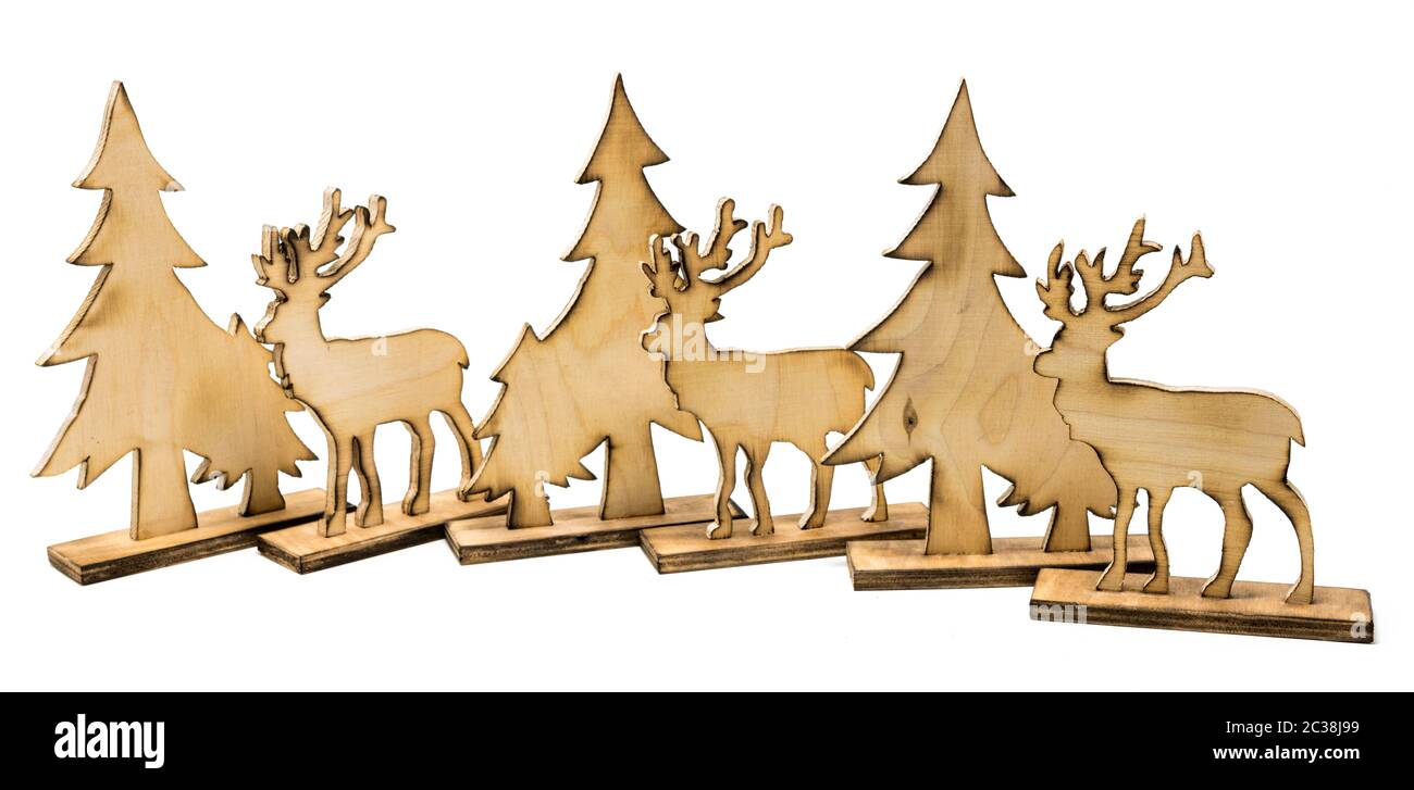 Cut out deer figure made of wood with dark edges and wooden fir trees ...