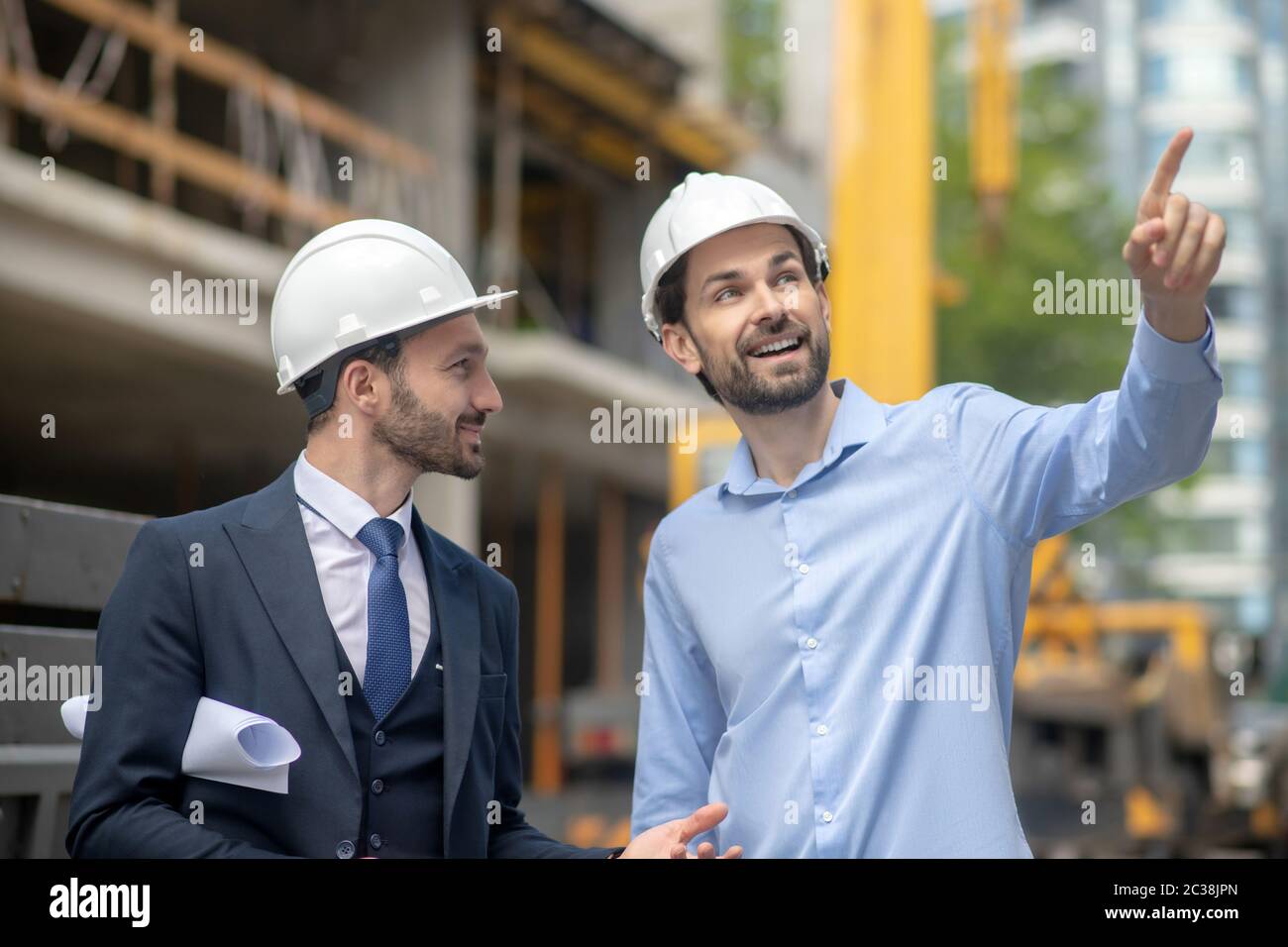 Building site. Foreman pointing his hand, showing something to building ...