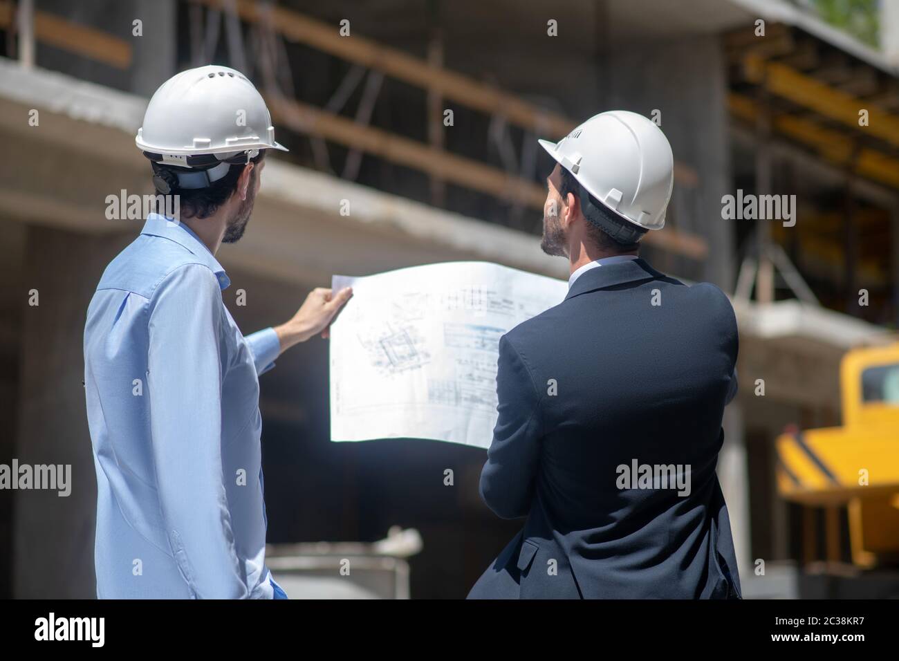 Building site. Building supervisor and foreman standing with their ...