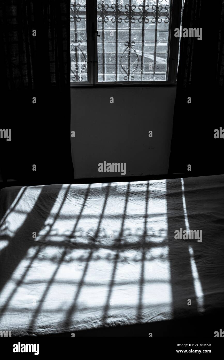 Window grille casting a shadow over bed, Valladolid, Mexico Stock Photo ...