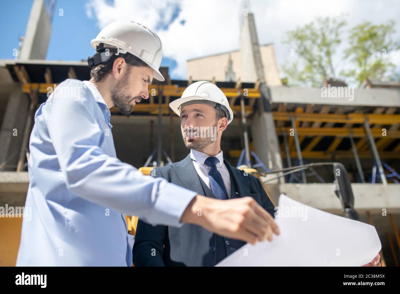 Building site. Building supervisor and foreman standing in front of ...