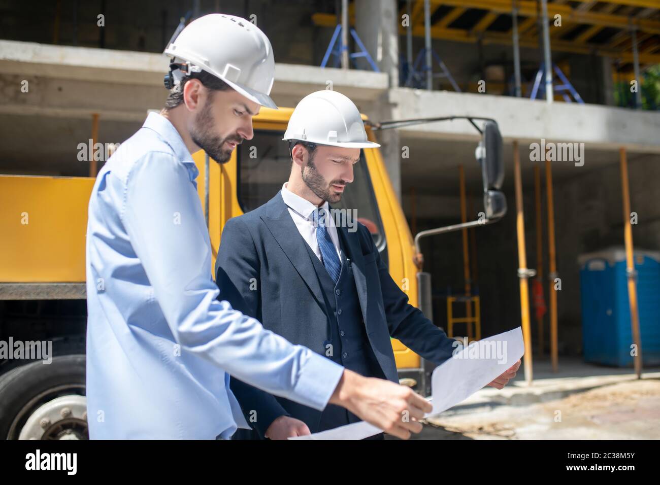 Building site. Building supervisor and foreman standing in front of ...