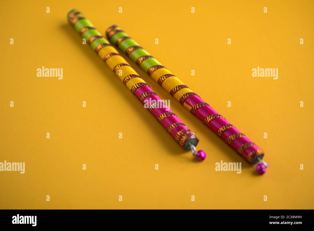 Dandiya sticks on a yellow background. Raas Garba or Dandiya Raas is ...