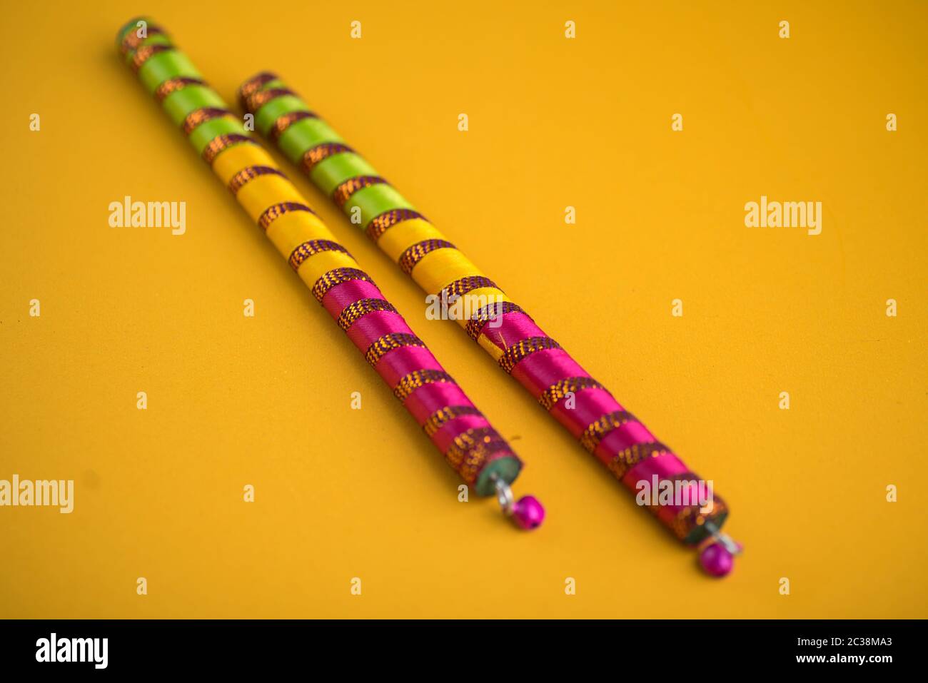 Dandiya sticks on a yellow background. Raas Garba or Dandiya Raas is ...