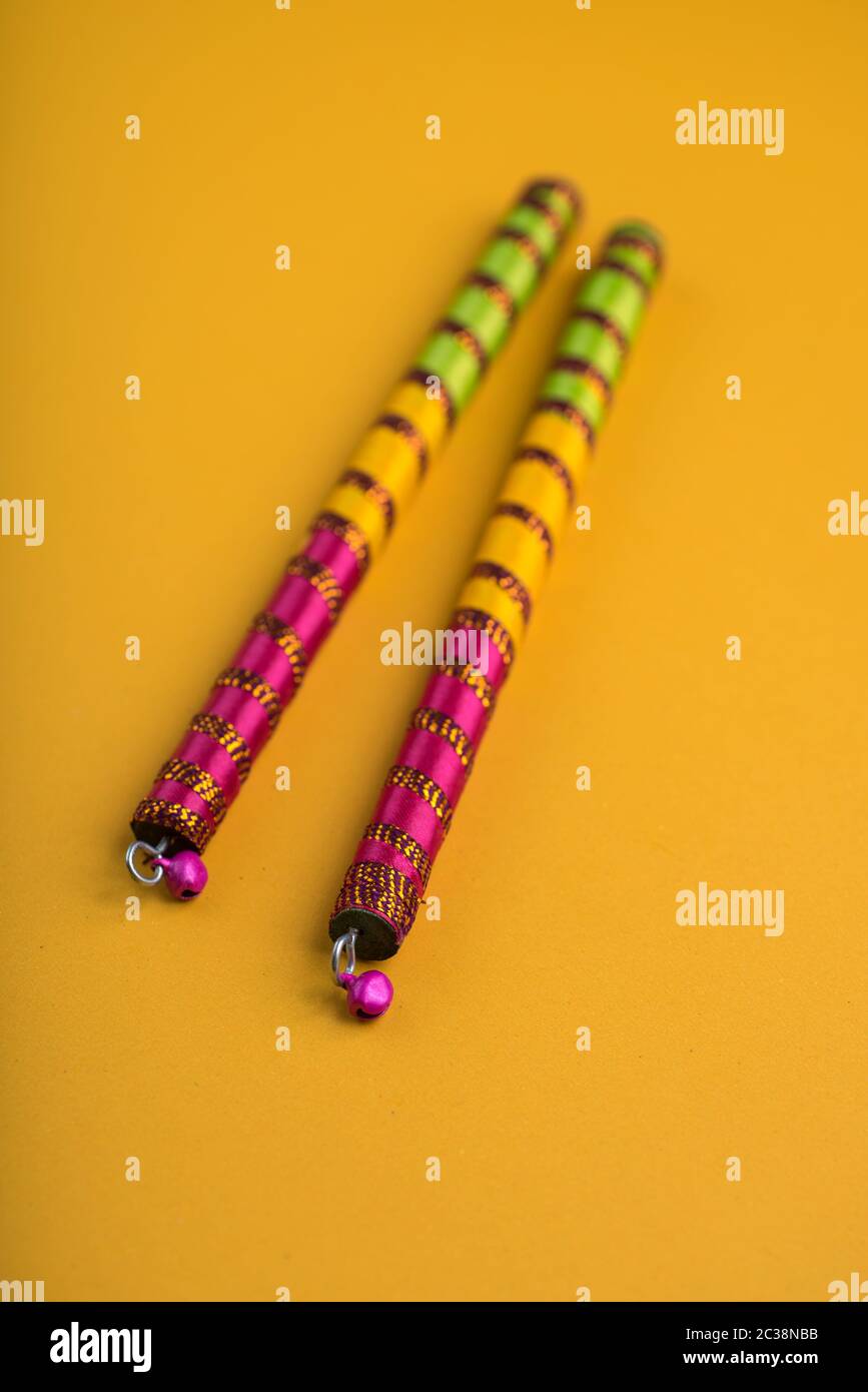Dandiya sticks on a yellow background. Raas Garba or Dandiya Raas is ...