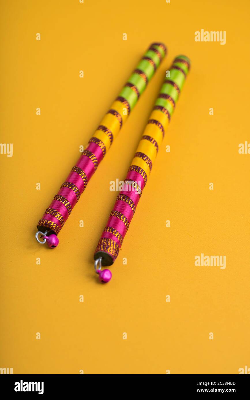 Dandiya sticks on a yellow background. Raas Garba or Dandiya Raas is ...