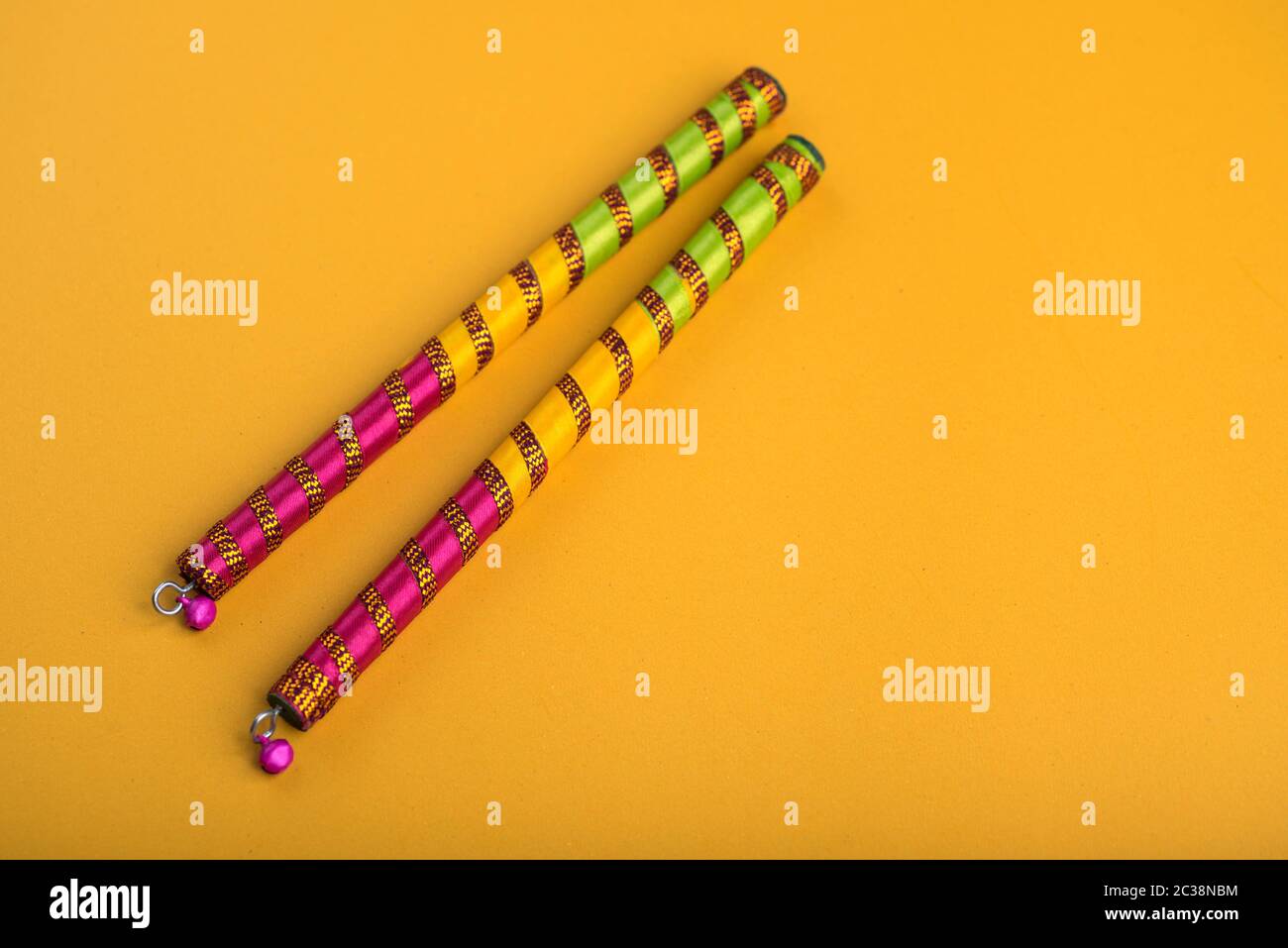 Dandiya sticks on a yellow background. Raas Garba or Dandiya Raas is ...