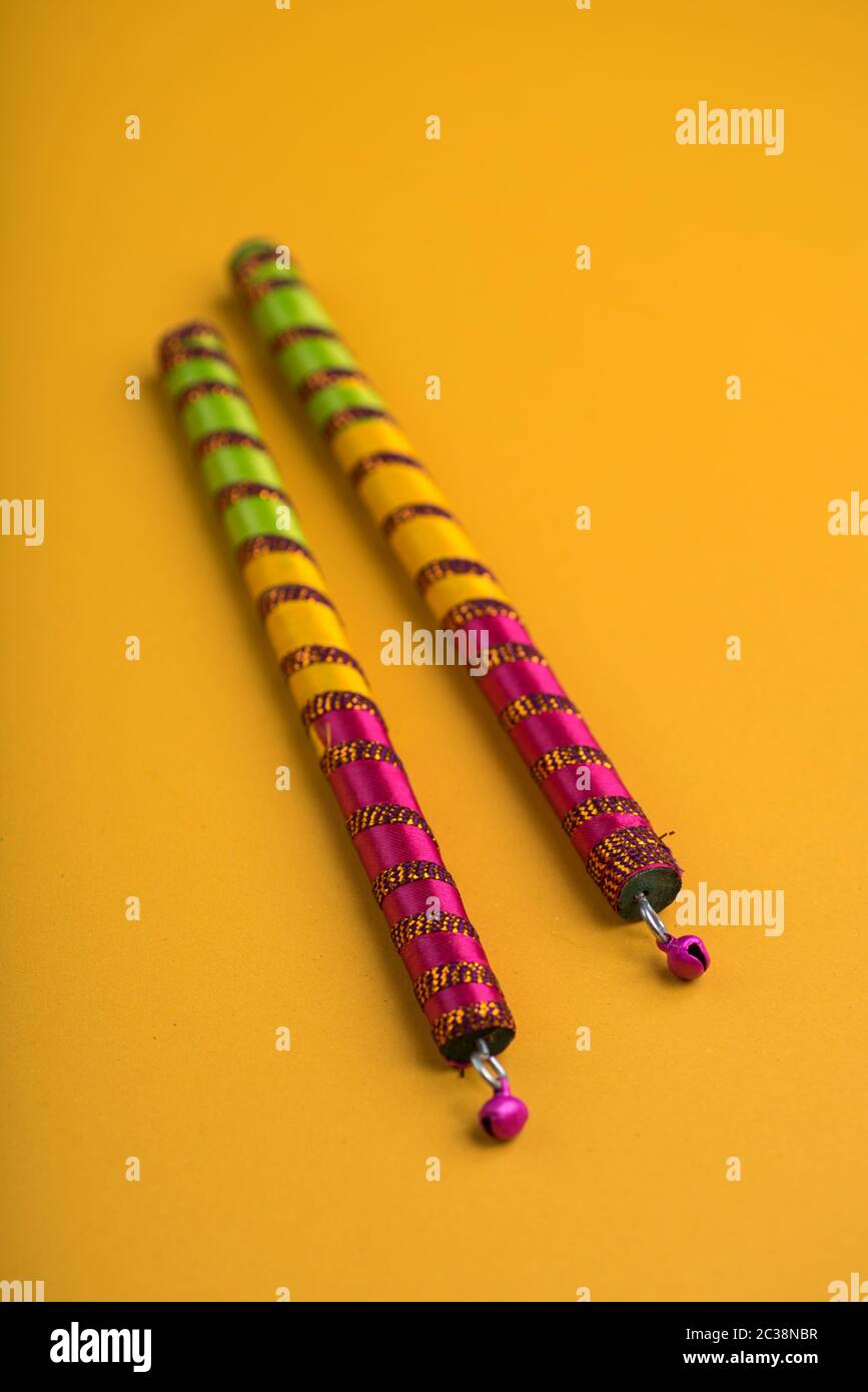 Dandiya sticks on a yellow background. Raas Garba or Dandiya Raas is ...