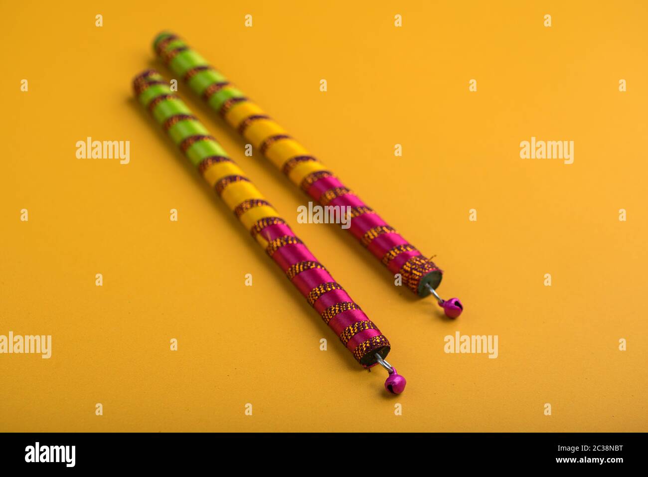 Dandiya sticks on a yellow background. Raas Garba or Dandiya Raas is ...