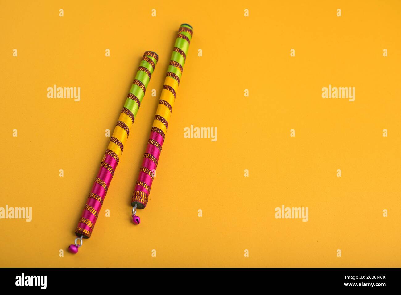 Dandiya sticks on a yellow background. Raas Garba or Dandiya Raas is ...