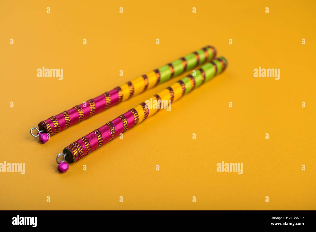 Dandiya sticks on a yellow background. Raas Garba or Dandiya Raas is ...