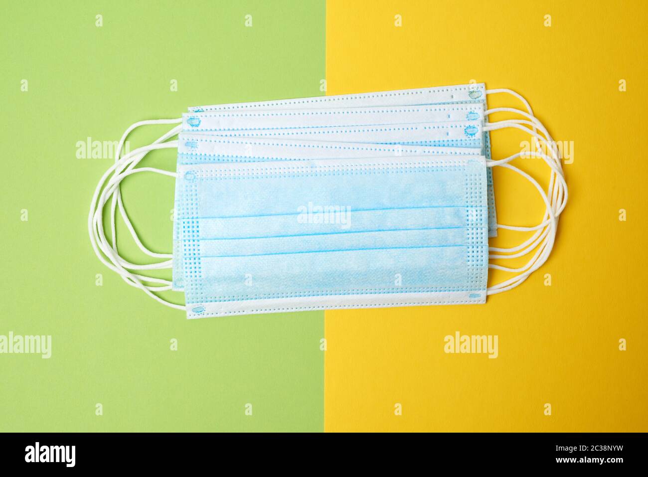 blue disposable medical mask on green-yellow, personal protective ...