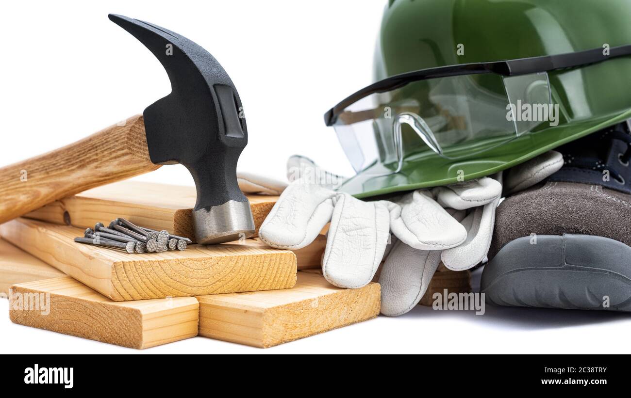 Close-up of a carpenter's hammer, helmet, goggles and protective gloves ...