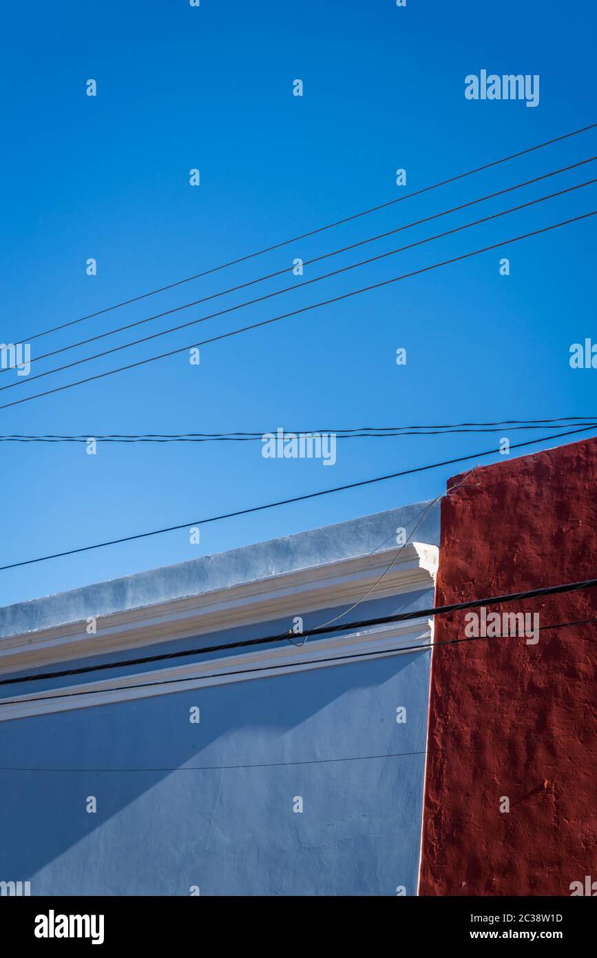 Blue and red wall of a house with electricity wires crossing over it ...