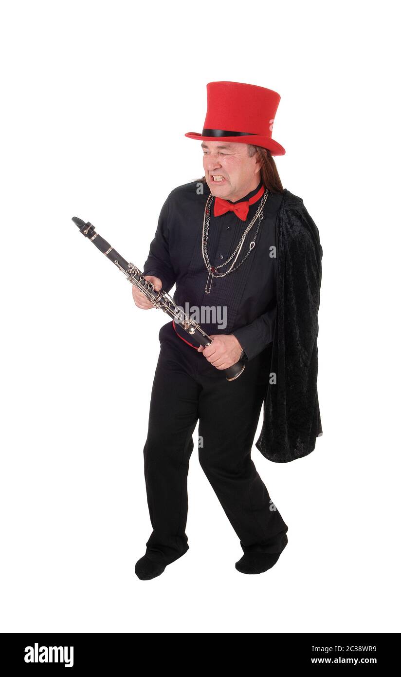 A indigenous man in a black shirt and pants and red hat dancing with ...