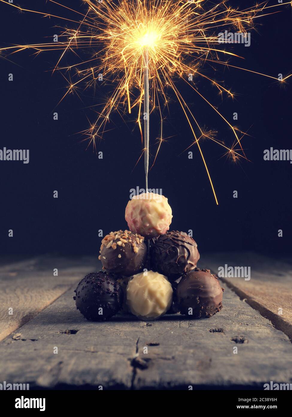 Stacked chocolated balls on a rustic table with a sparkler Stock Photo ...