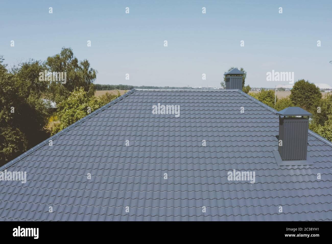 Modern roof made of metal. Gray-blue metal roof tiles on the roof of ...