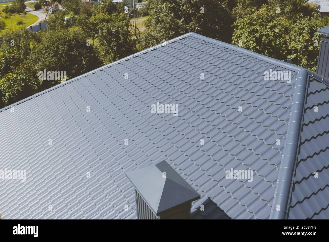 Modern roof made of metal. Gray-blue metal roof tiles on the roof of ...