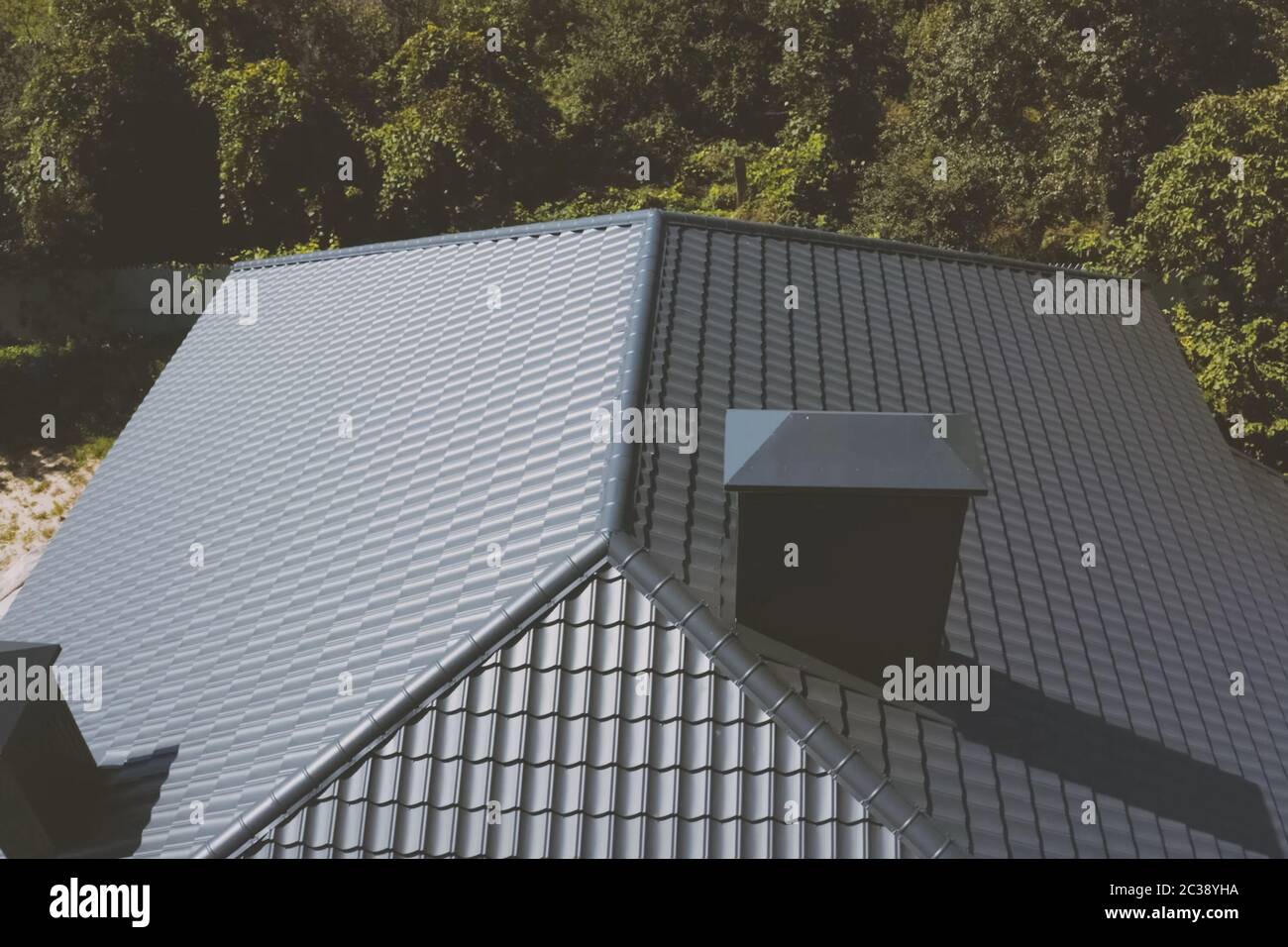 Modern roof made of metal. Gray-blue metal roof tiles on the roof of ...