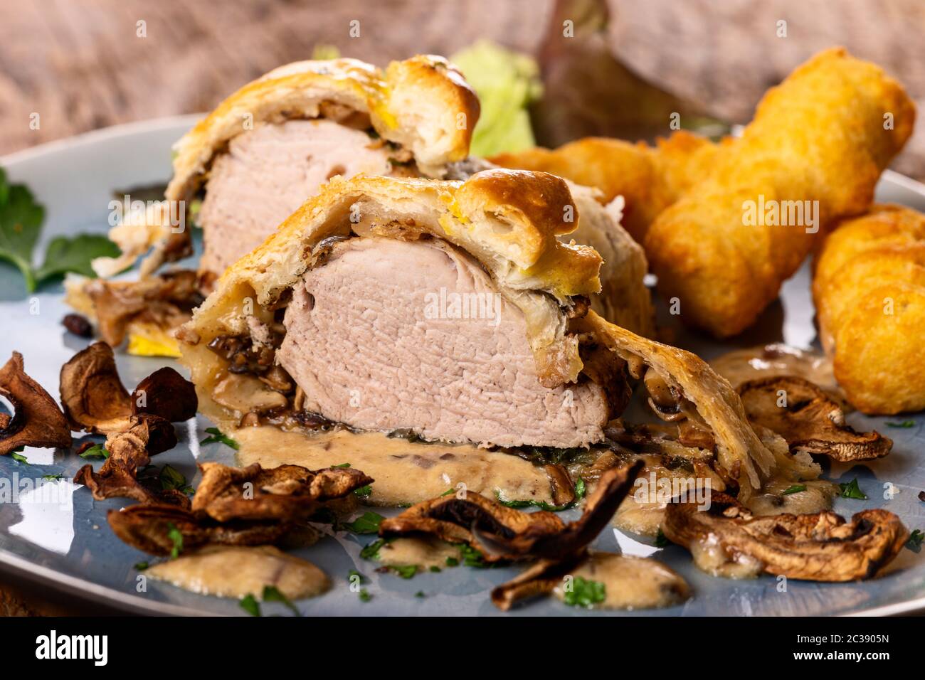 pork filet in puff pastry with croquettes Stock Photo - Alamy